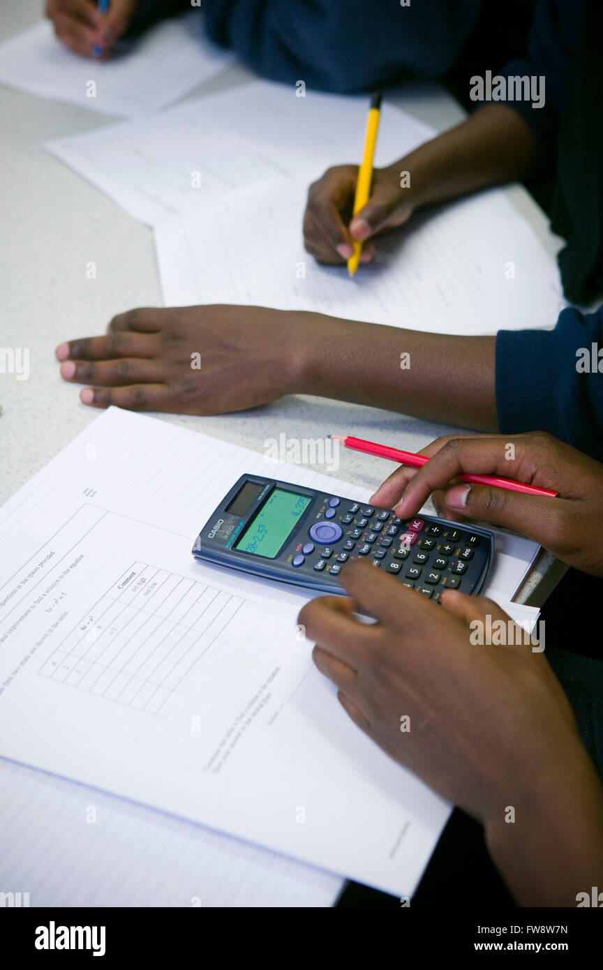 Pupils at a school,collge or university using calculators on their desk ...