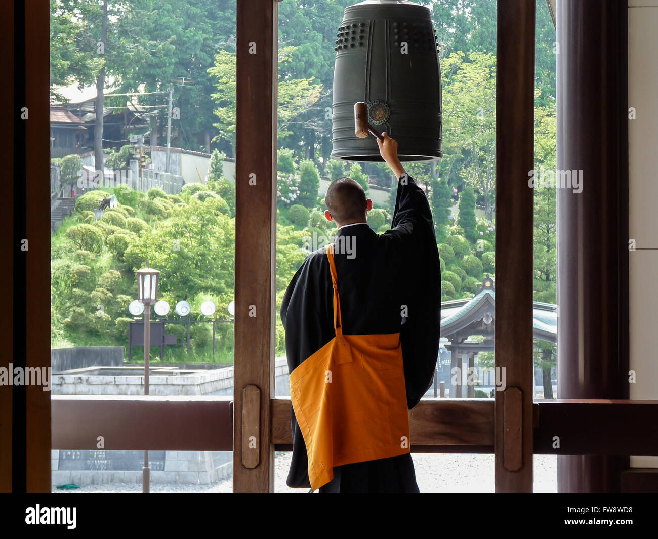 A Buddhist Monk ringing a temple bell Stock Photo - Alamy