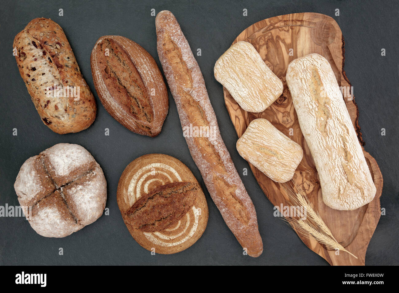 Homemade bread selection on olive wood board on slate background Stock ...