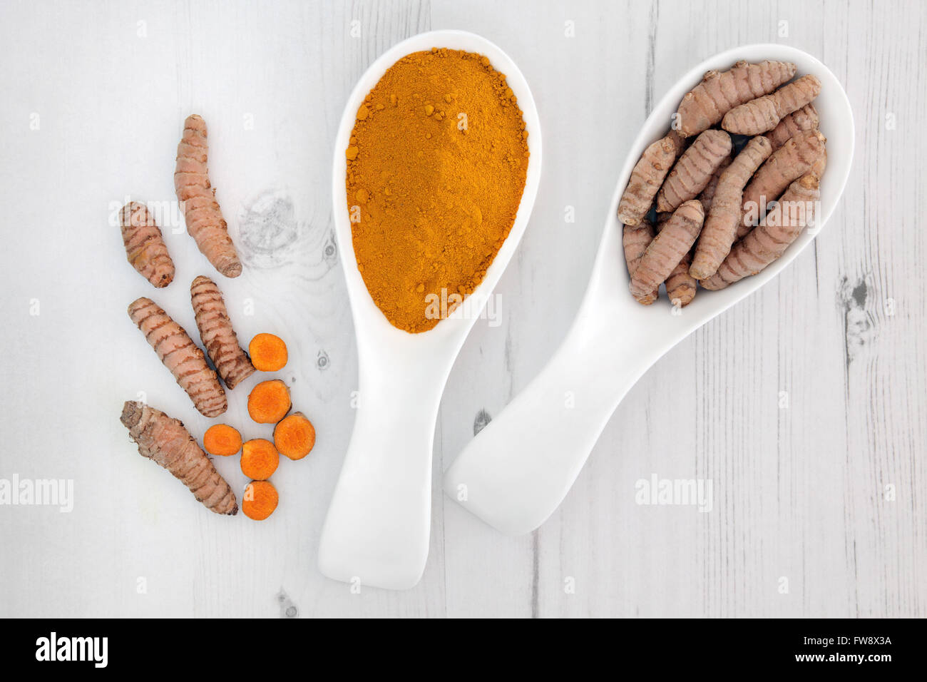 Turmeric spice fresh and dried in porcelain scoops and loose over ...