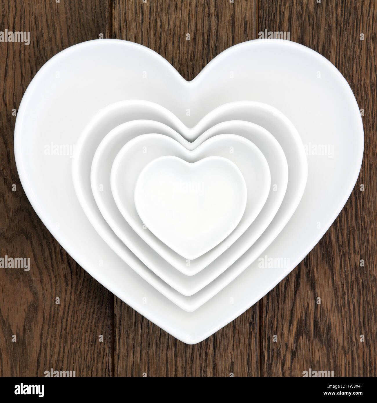 Heart shaped porcelain dishes over old oak background Stock Photo - Alamy