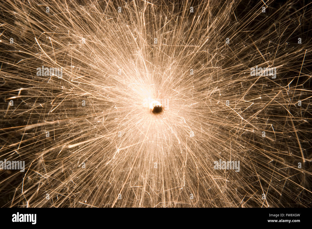 Sparks from a sparkler radiate outwards from the central core of the ...