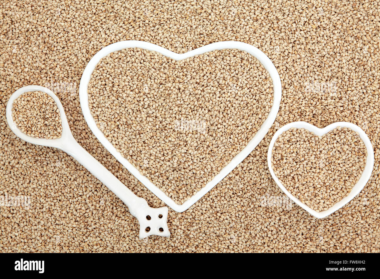 Sesame seed health food in heart shaped porcelain dishes and spoon ...