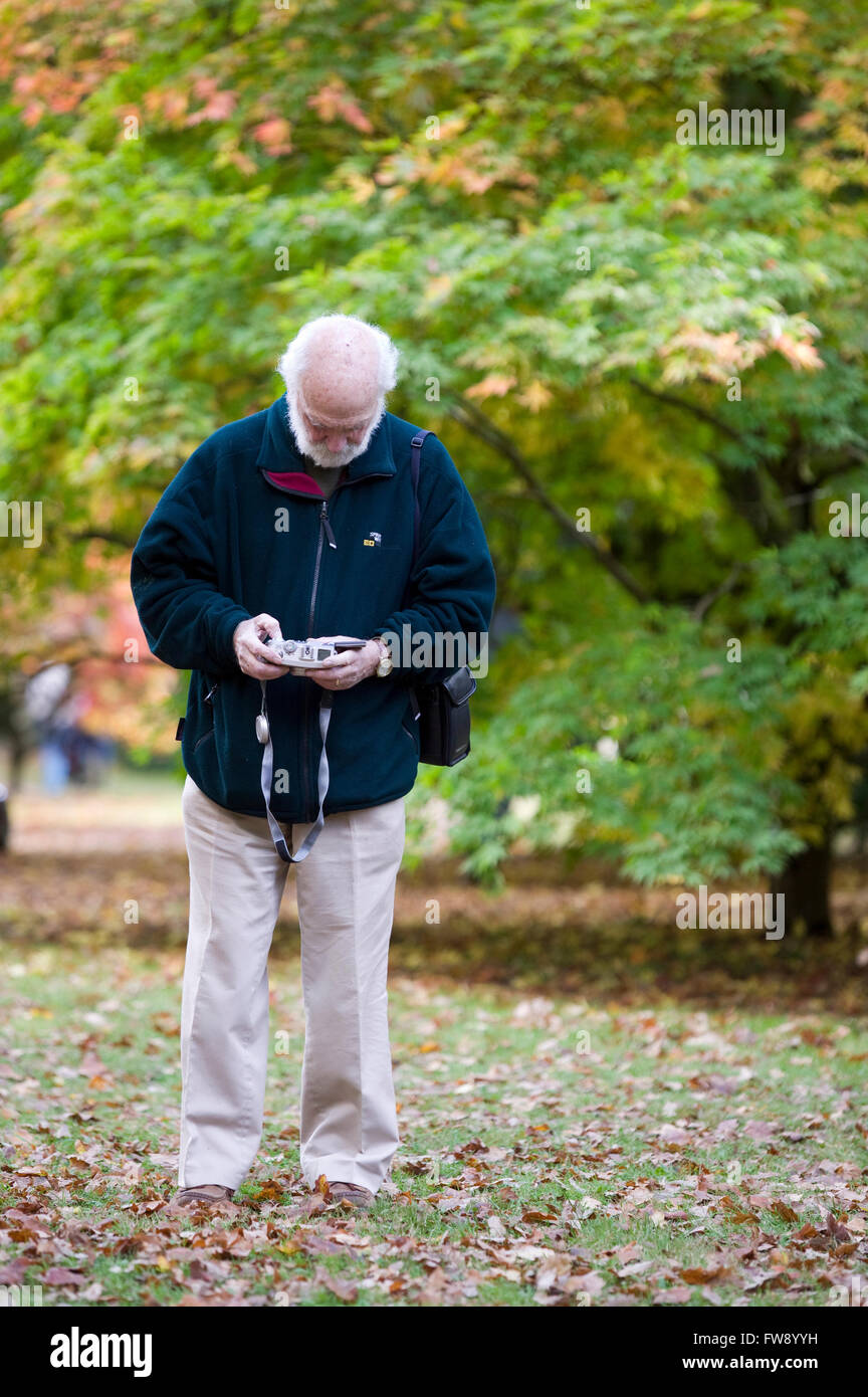 Checking the back of his digital camera a man makes sure his latest ...
