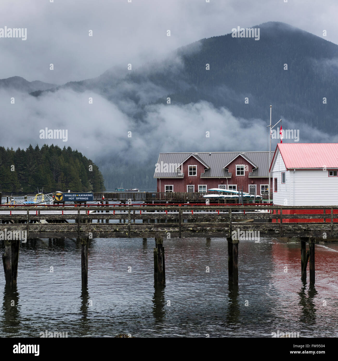 Buildings on a pier with mountains in the background, Pacific Rim ...