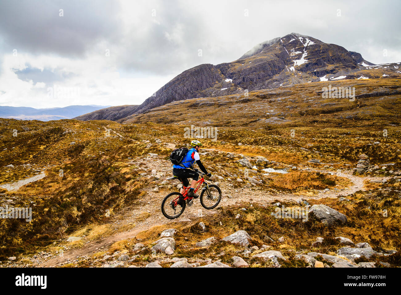 Mountain biker at the pass of Drochaid Coire Lair in Torridon Highland ...