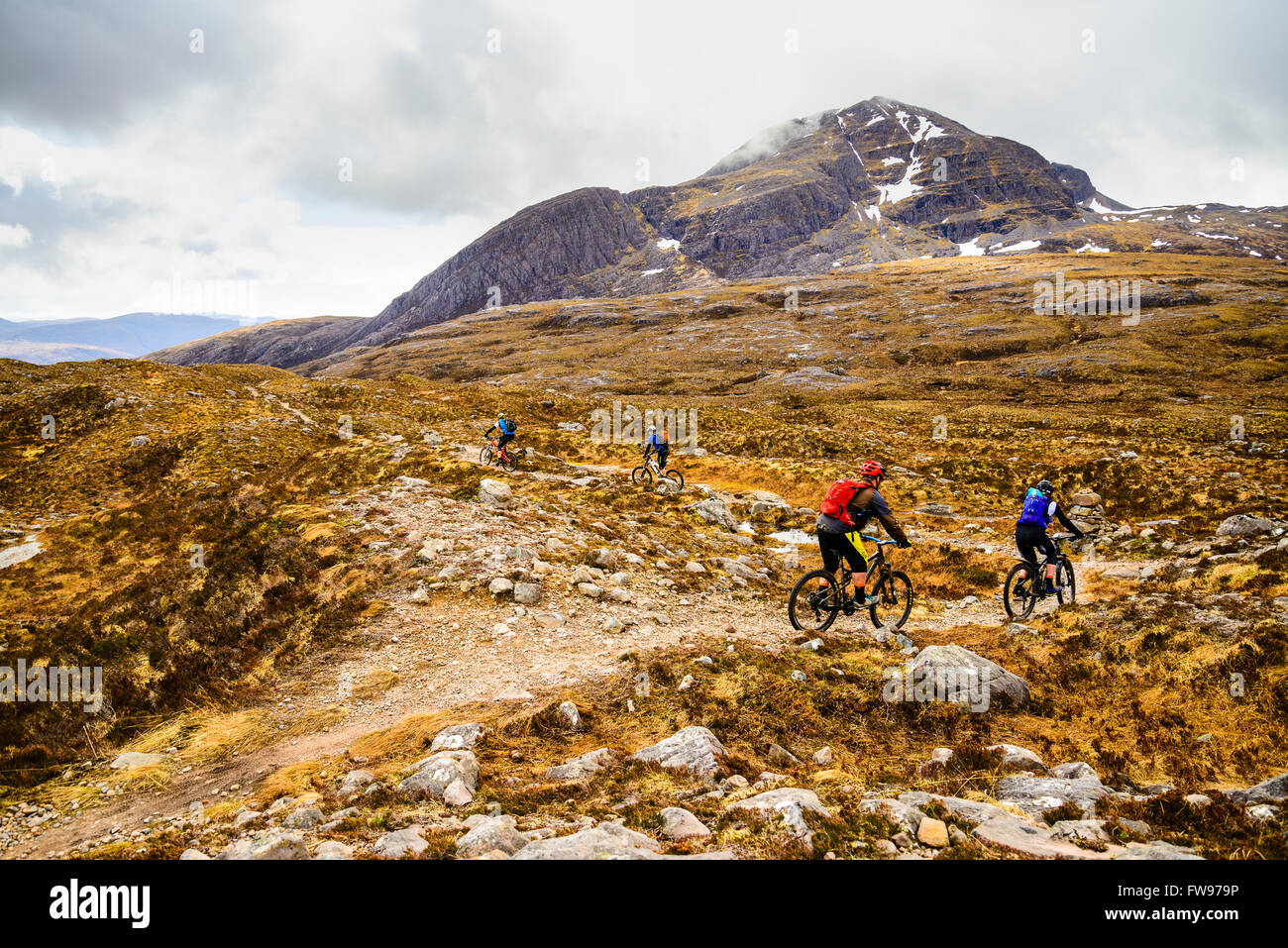 Mountain bikers at the pass of Drochaid Coire Lair in Torridon Highland ...
