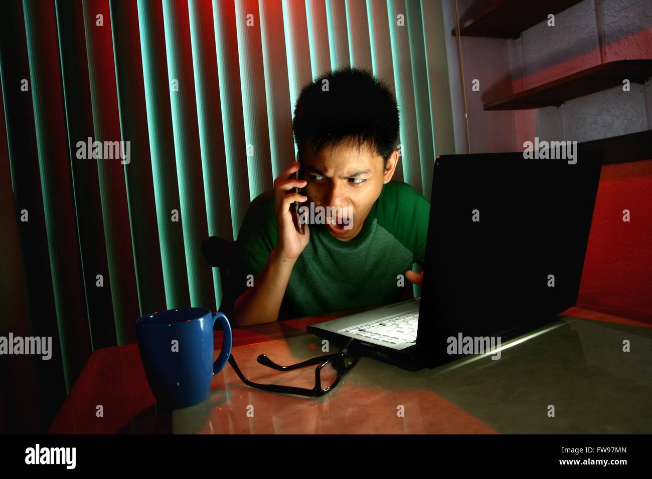 Young Teen using a cellphone or smartphone in front of a laptop ...