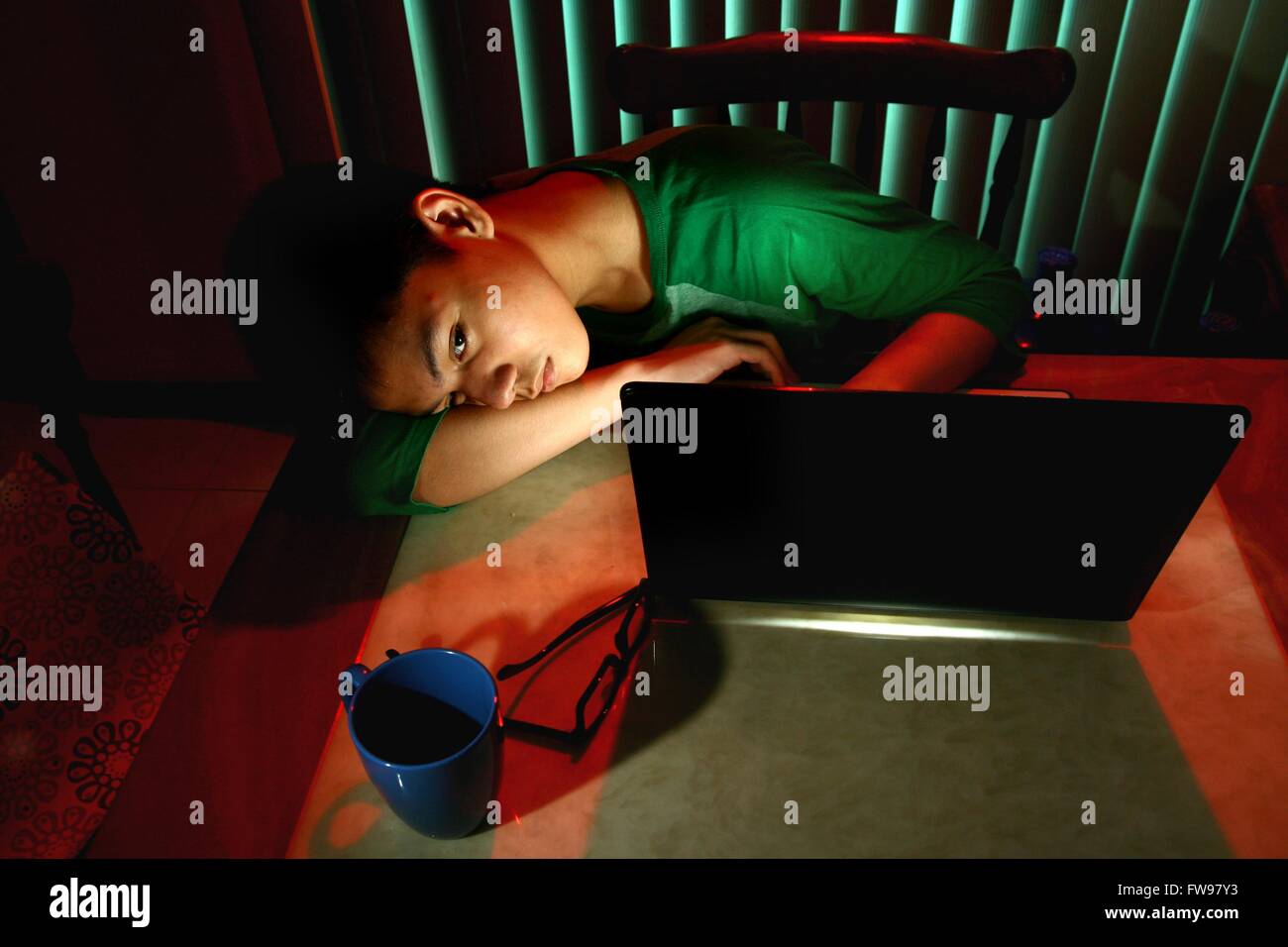Teen resting in front of a laptop computer Stock Photo - Alamy