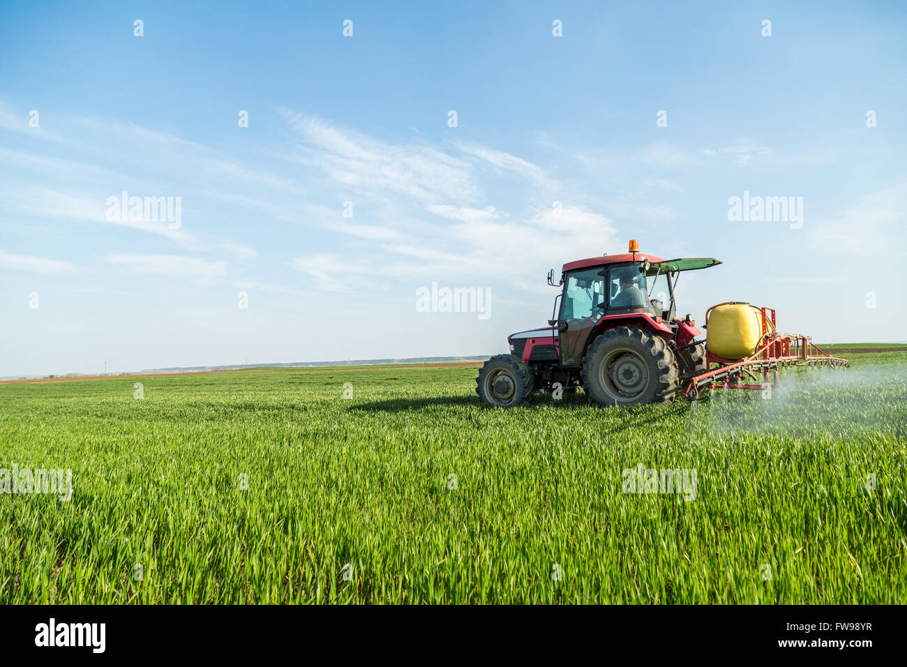 Farmer spraying green wheat field Stock Photo - Alamy