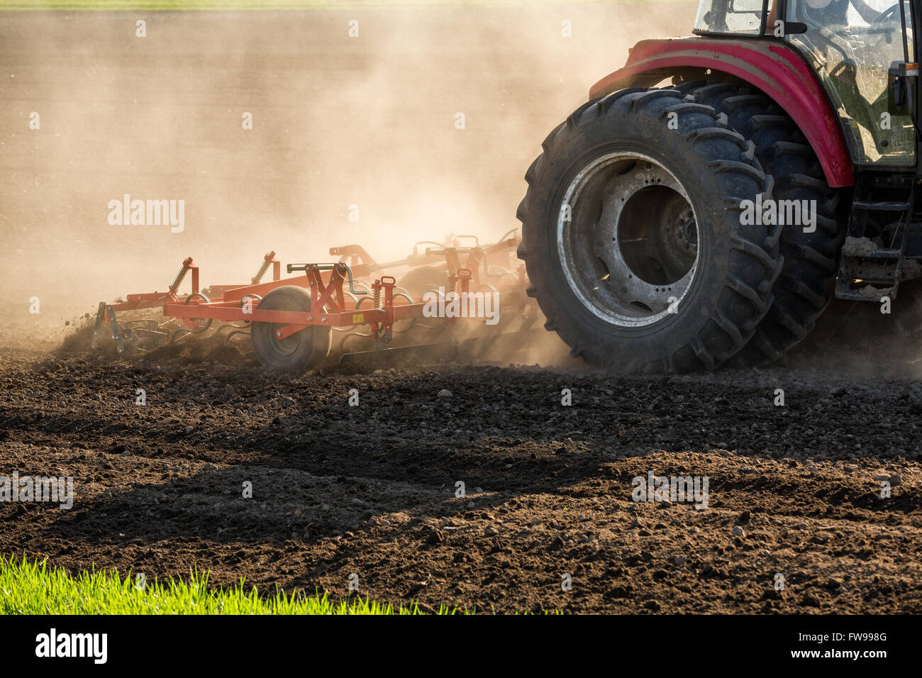 Tractor cultivating field at spring Stock Photo - Alamy
