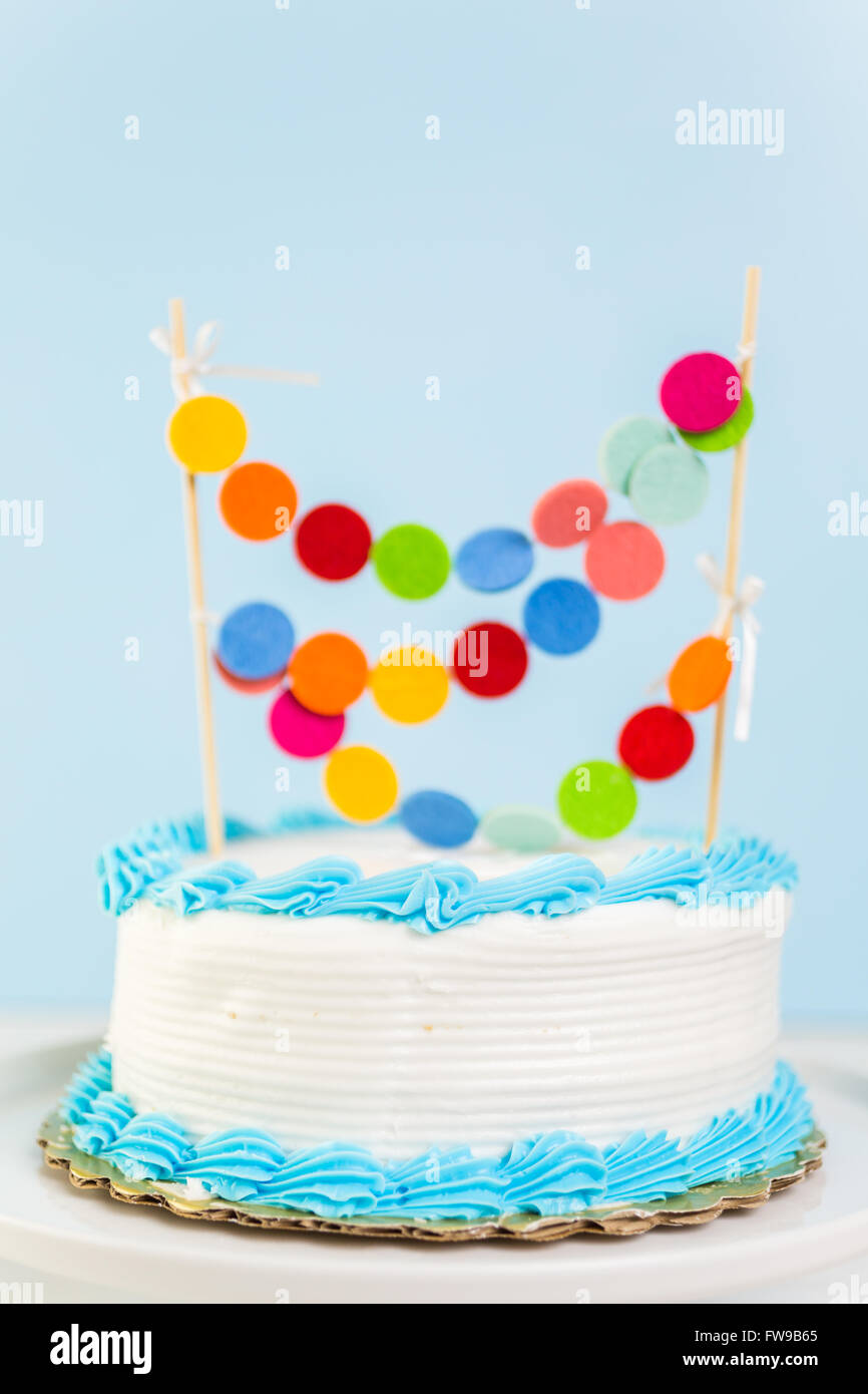 Simple white Birthday cake with cake garland Stock Photo - Alamy
