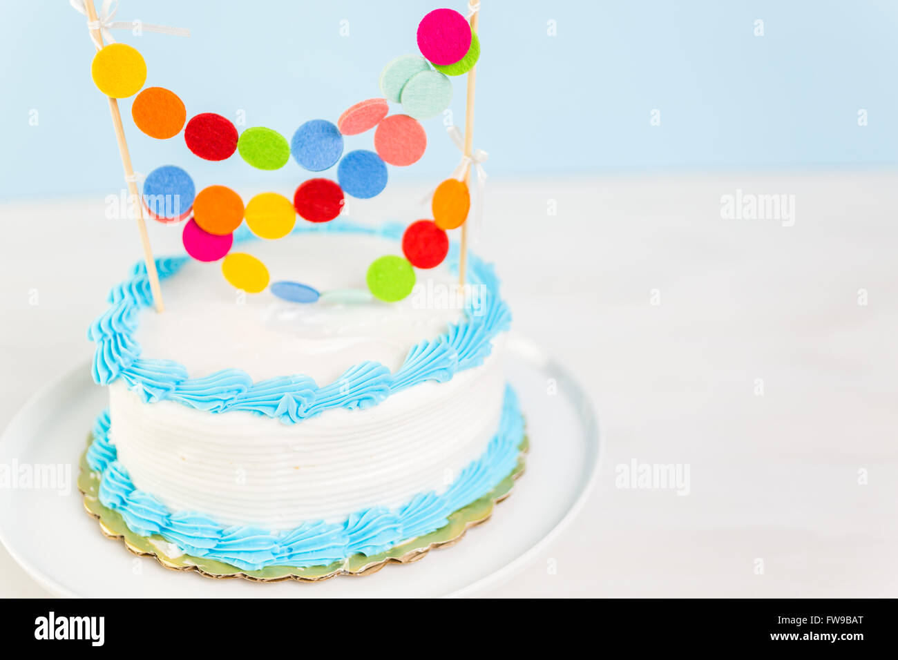 Simple white Birthday cake with cake garland Stock Photo - Alamy