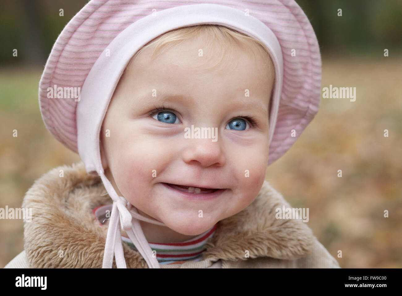 Little girl with pink cap and two teeth, portrait Stock Photo - Alamy