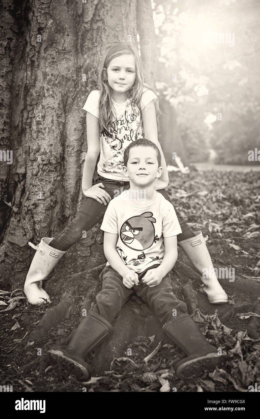 two children posing in park at the big tree Stock Photo - Alamy