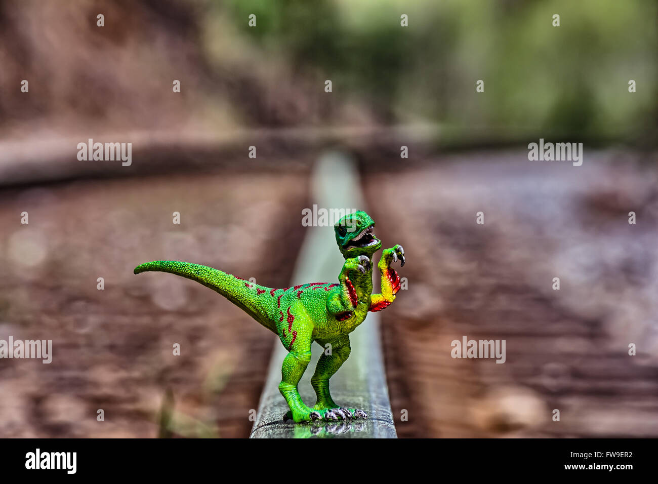 Green Velociraptor dinosaur walking on rail railroad tracks Stock Photo ...
