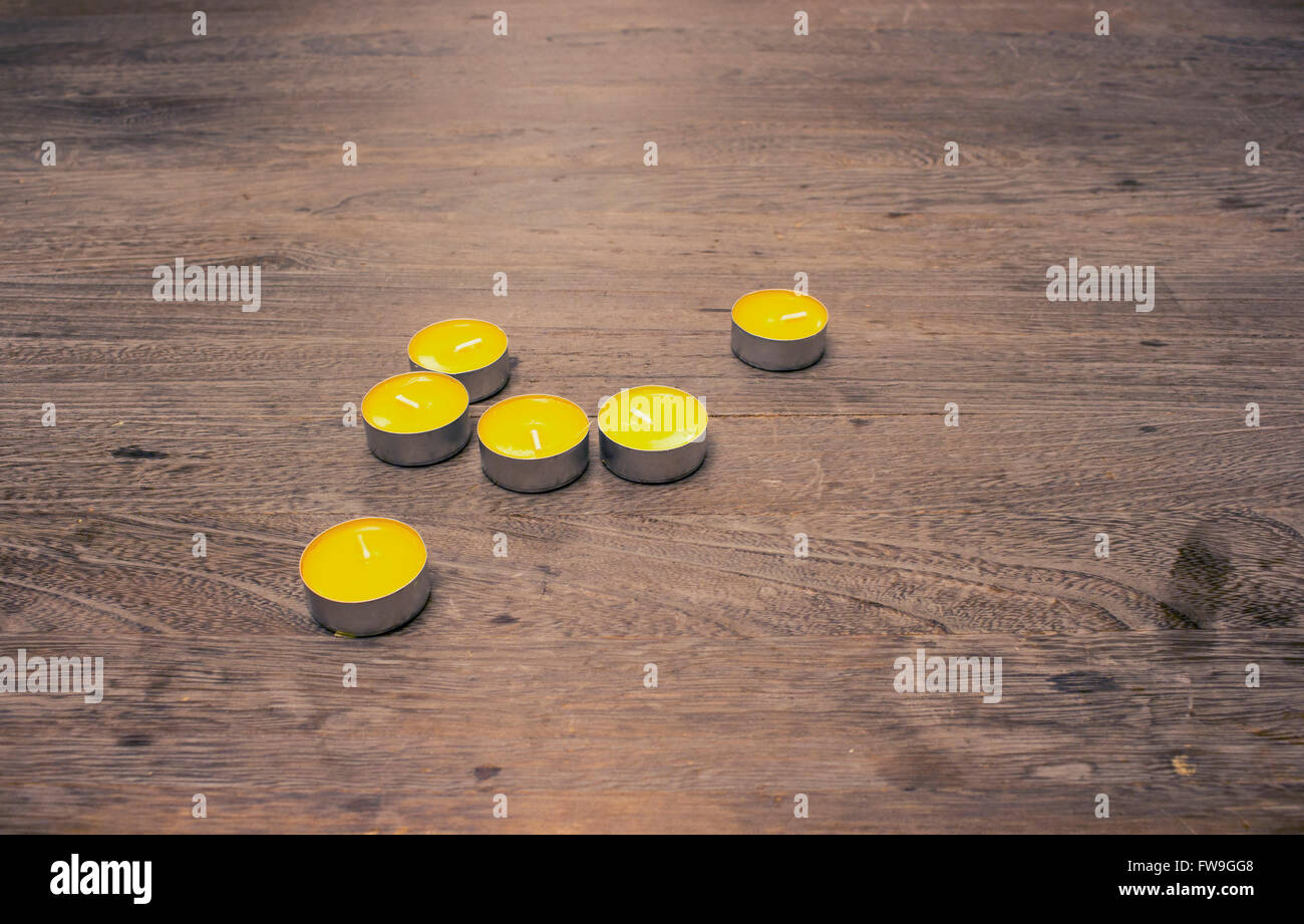 green yellow tea lights on wood table Stock Photo - Alamy