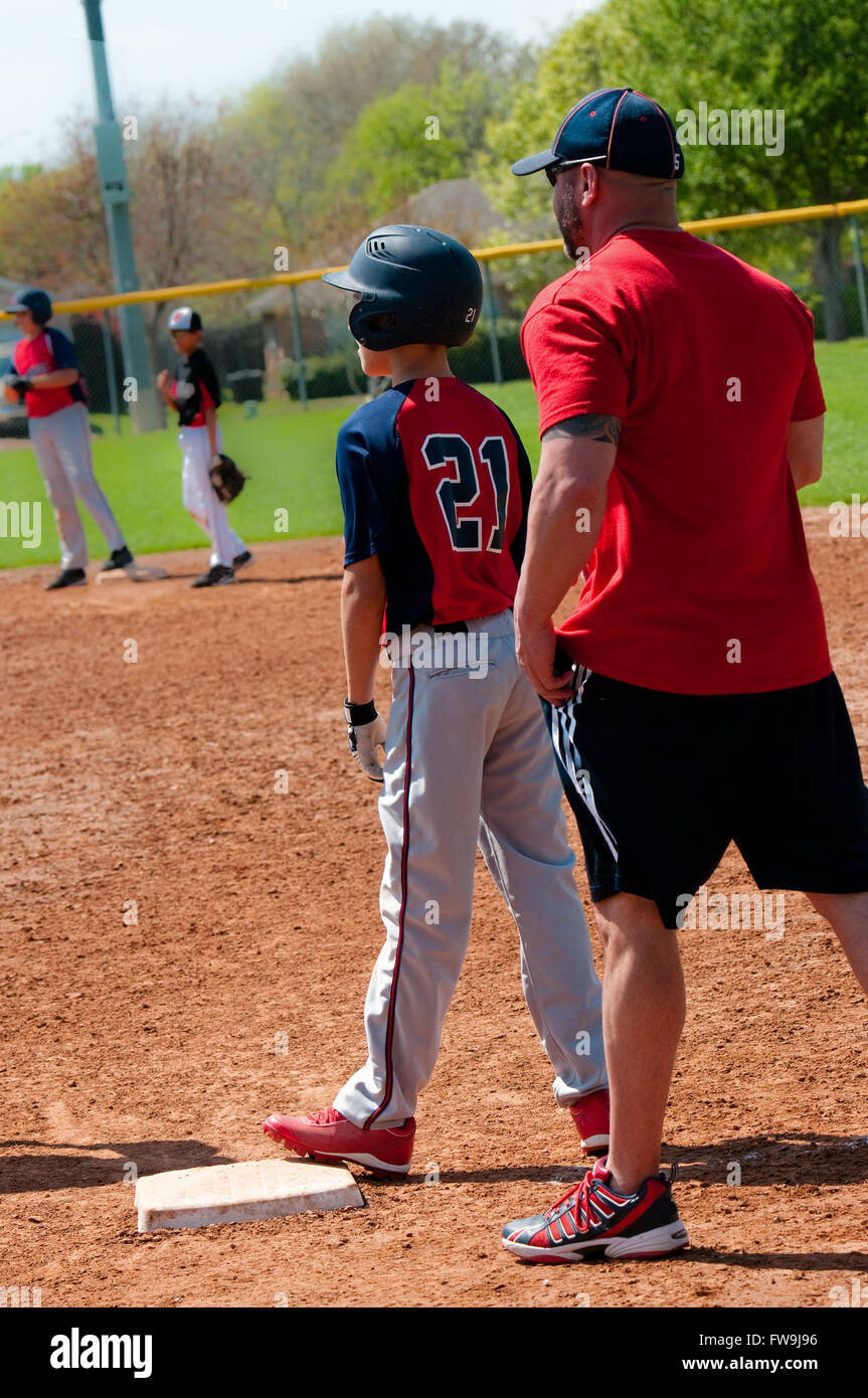 Teen baseball player and baseball coach at first base Stock Photo - Alamy