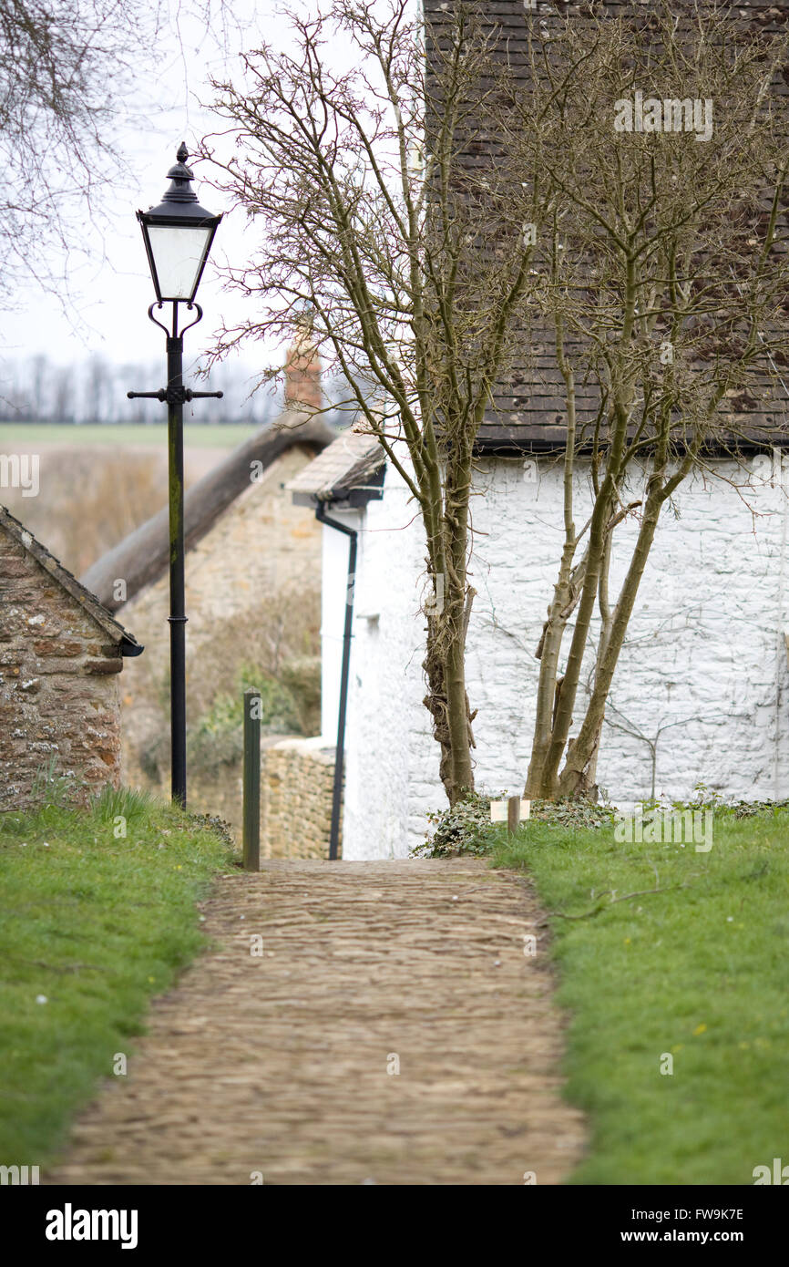 Lamp post and pathway to cottages in a village Stock Photo - Alamy