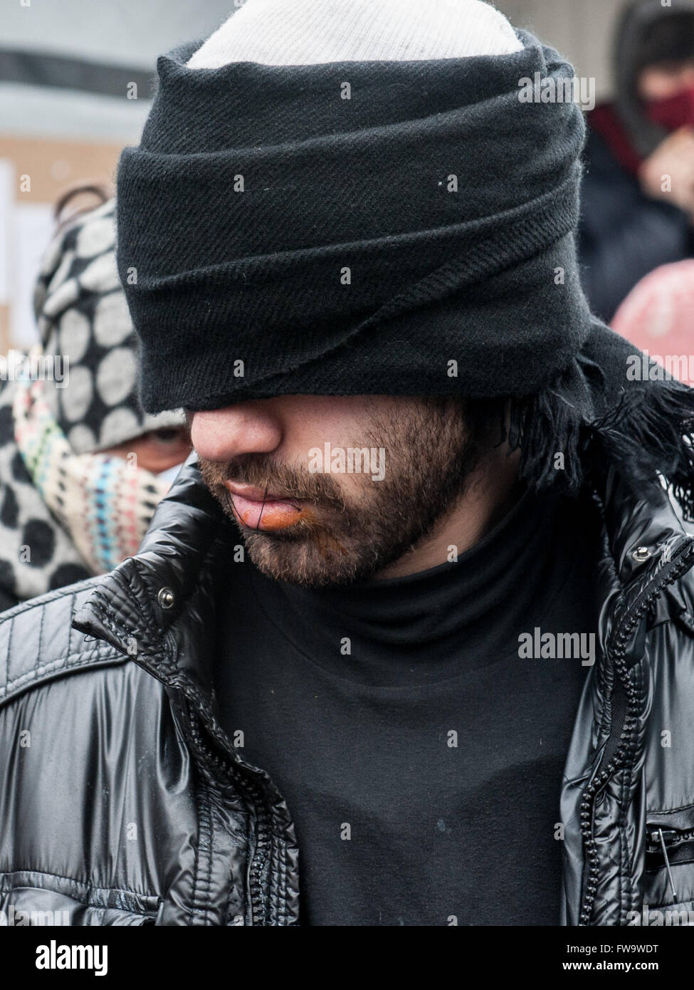 A group of Iranian asylum seekers stitch up their mouths to signify ...