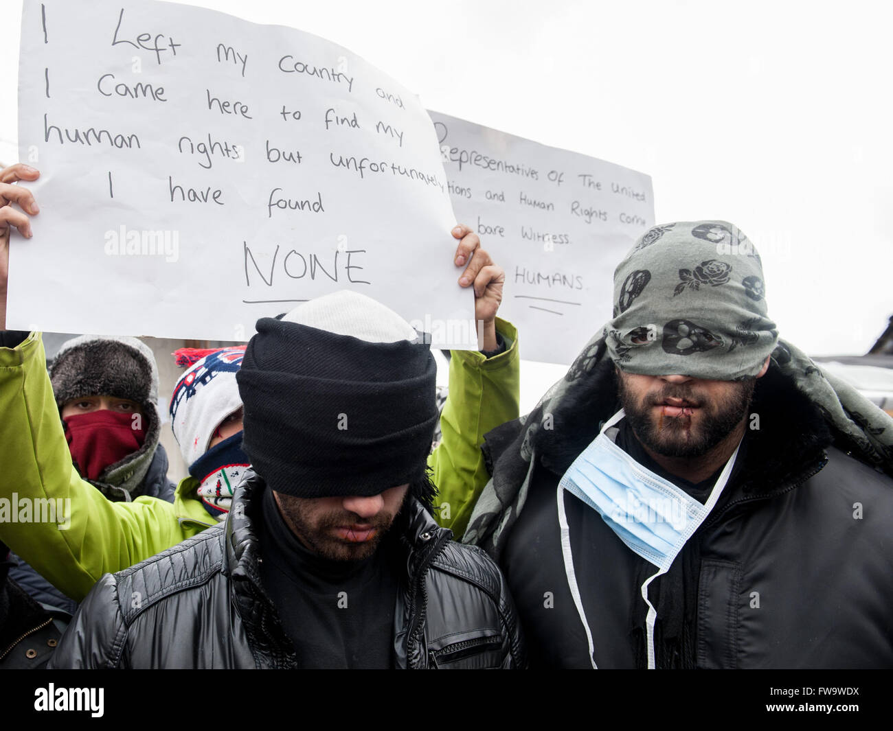 A group of Iranian asylum seekers stitch up their mouths to signify ...