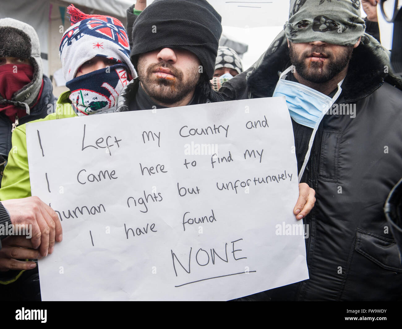 A group of Iranian asylum seekers stitch up their mouths to signify ...