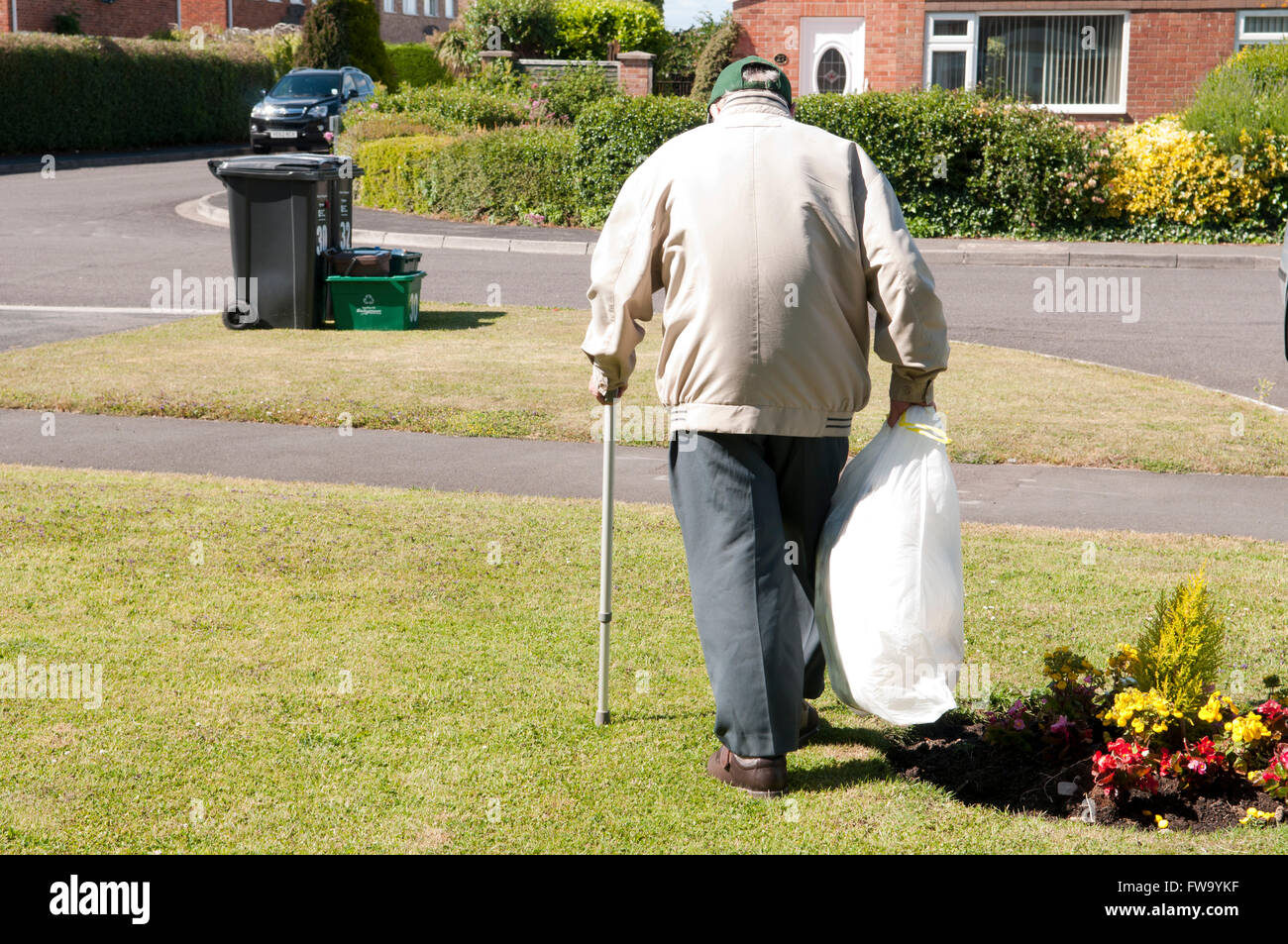 Rear view of an elderly man taking his rubbish out to the bin Stock ...