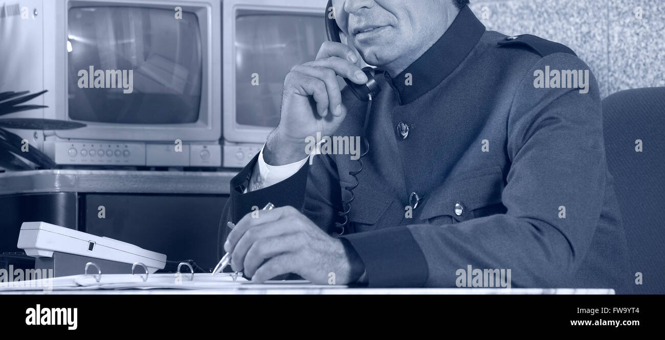 Male receptionist speaking by telephone in blue tone Stock Photo - Alamy