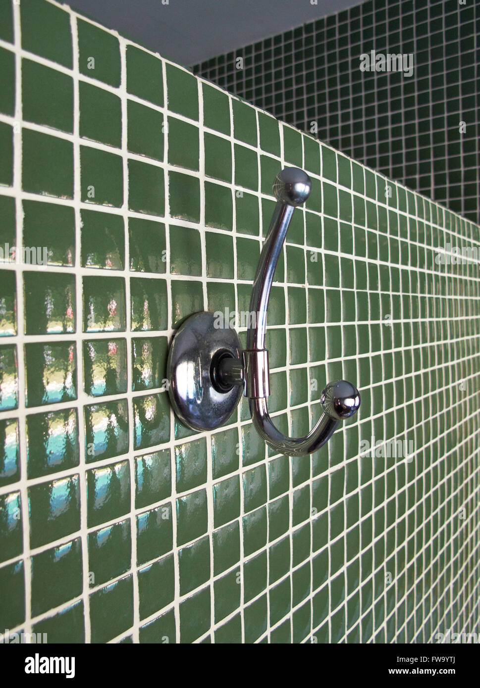 Metallic cloth hanger on a green wall. Vertical format Stock Photo - Alamy