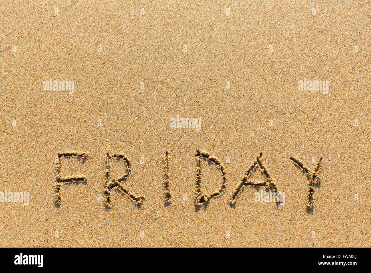 Friday - written manually on the texture of sea sand Stock Photo - Alamy