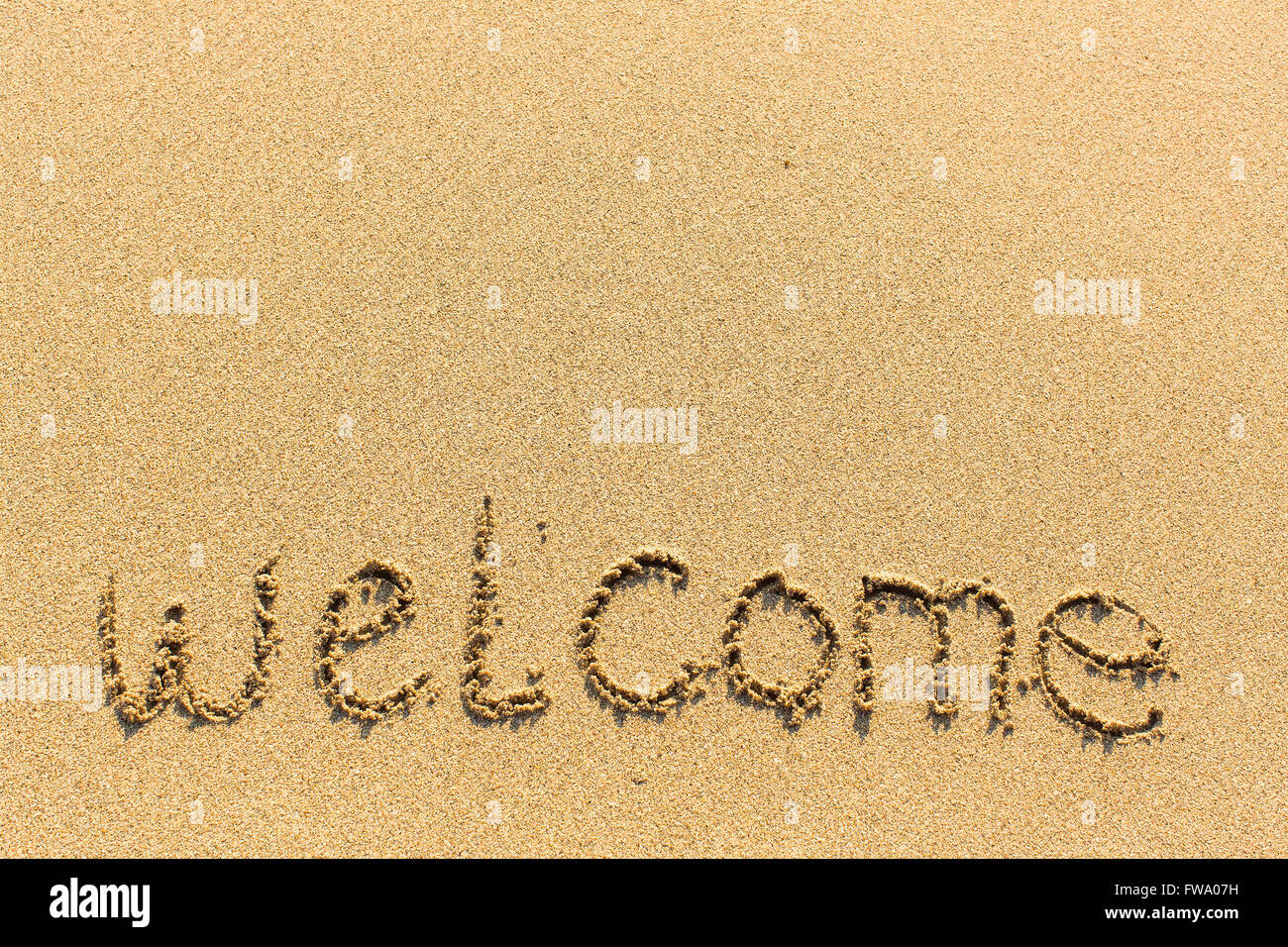 Welcome is the inscription by hand on the sand texture Stock Photo - Alamy