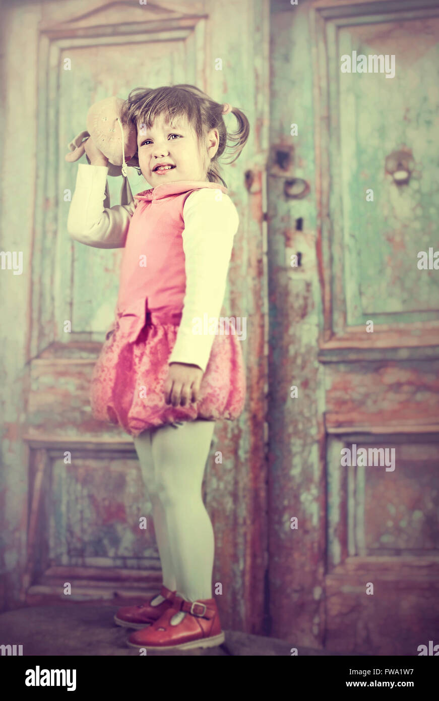 a small girl standing by the old door crying Stock Photo - Alamy
