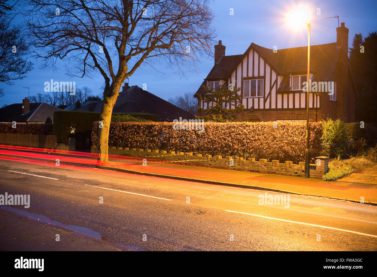 Street lighting at dusk witrh a traffic light trail Stock Photo - Alamy