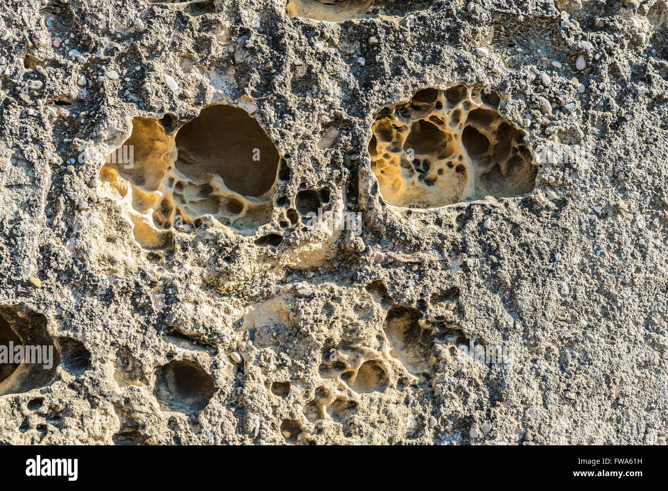 Eroded stone wall with holes as background Stock Photo - Alamy