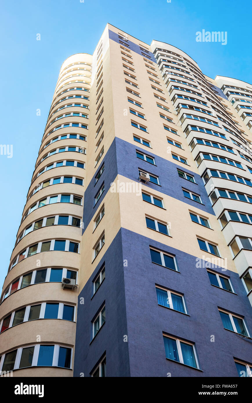 New tall apartment building against blue sky background Stock Photo - Alamy