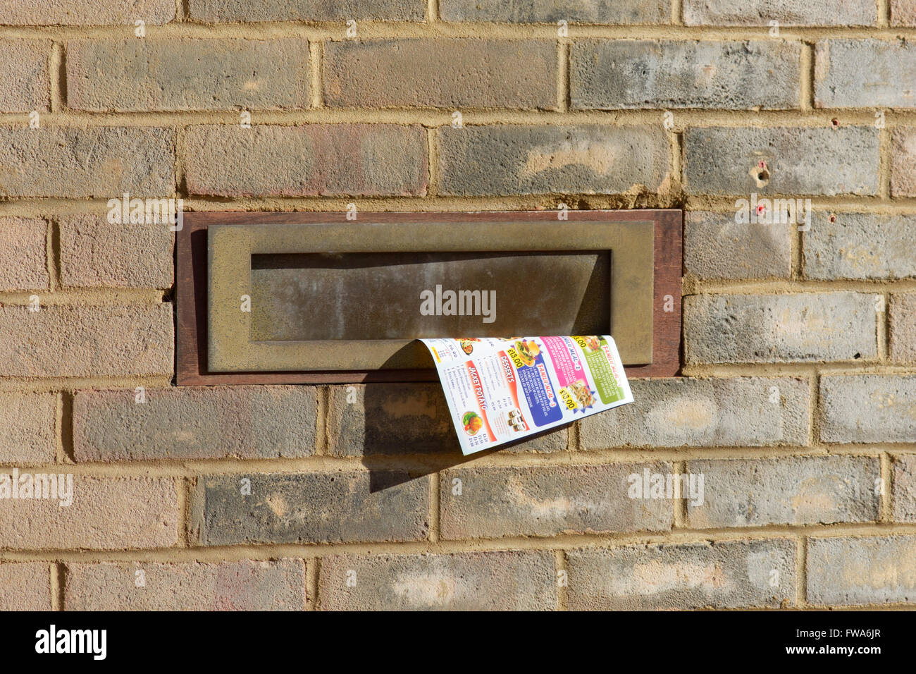 Fast food junk mail hanging out of letter box Stock Photo - Alamy