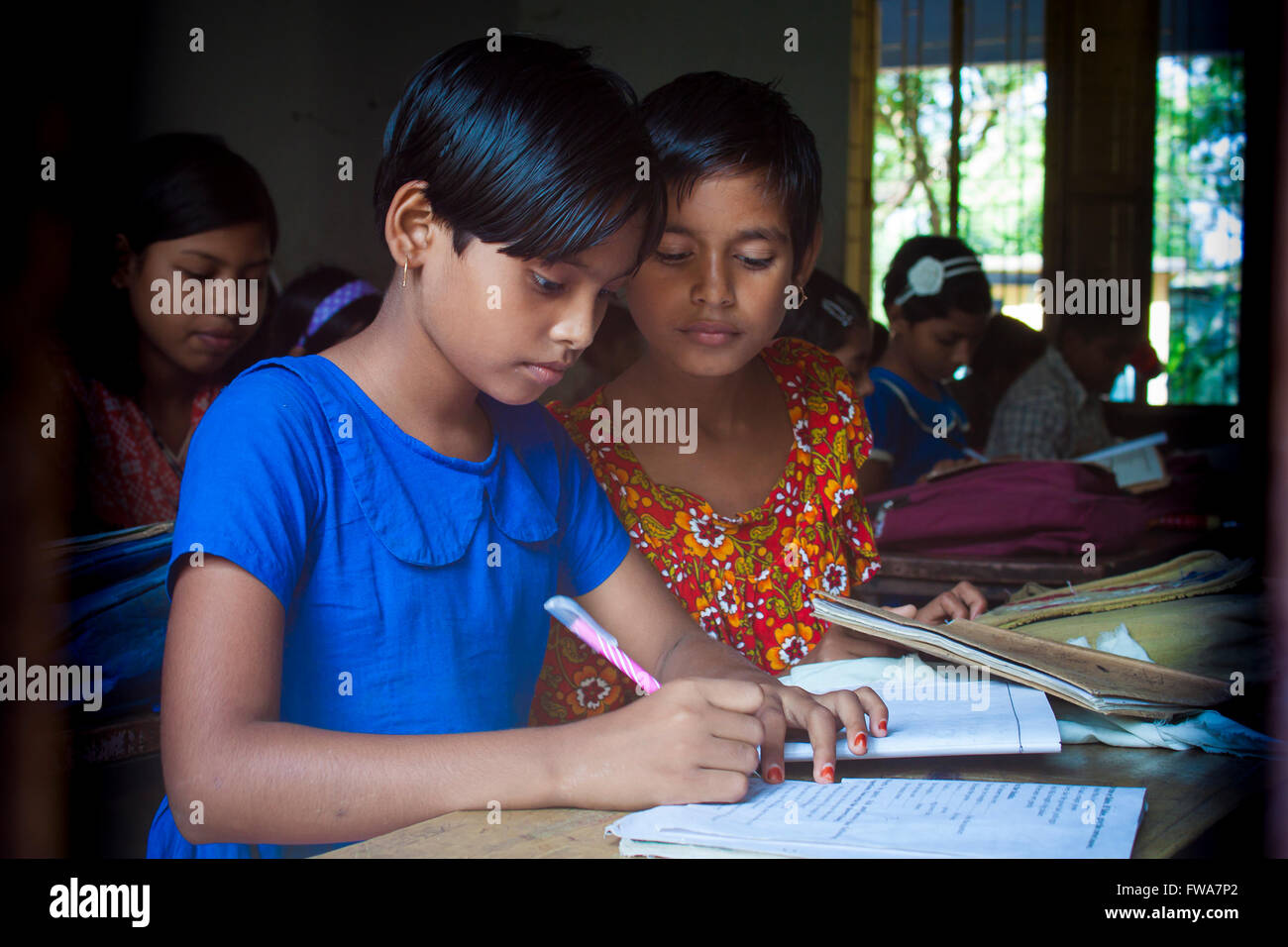 A little Girl writing NGO supported rural primary school classroom in ...