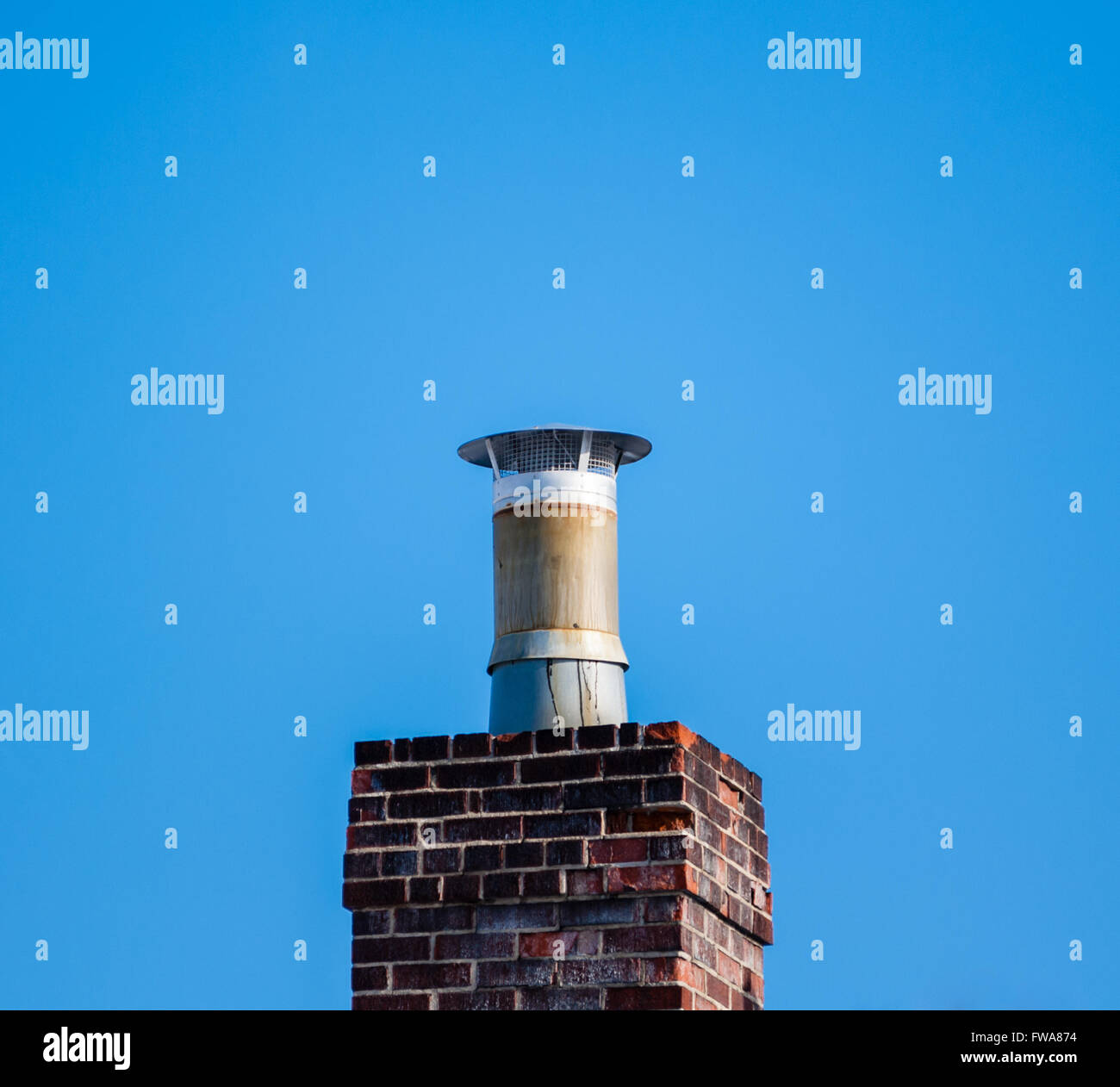 Top of old dark brick chimney with filter on clear blue sky Stock Photo ...