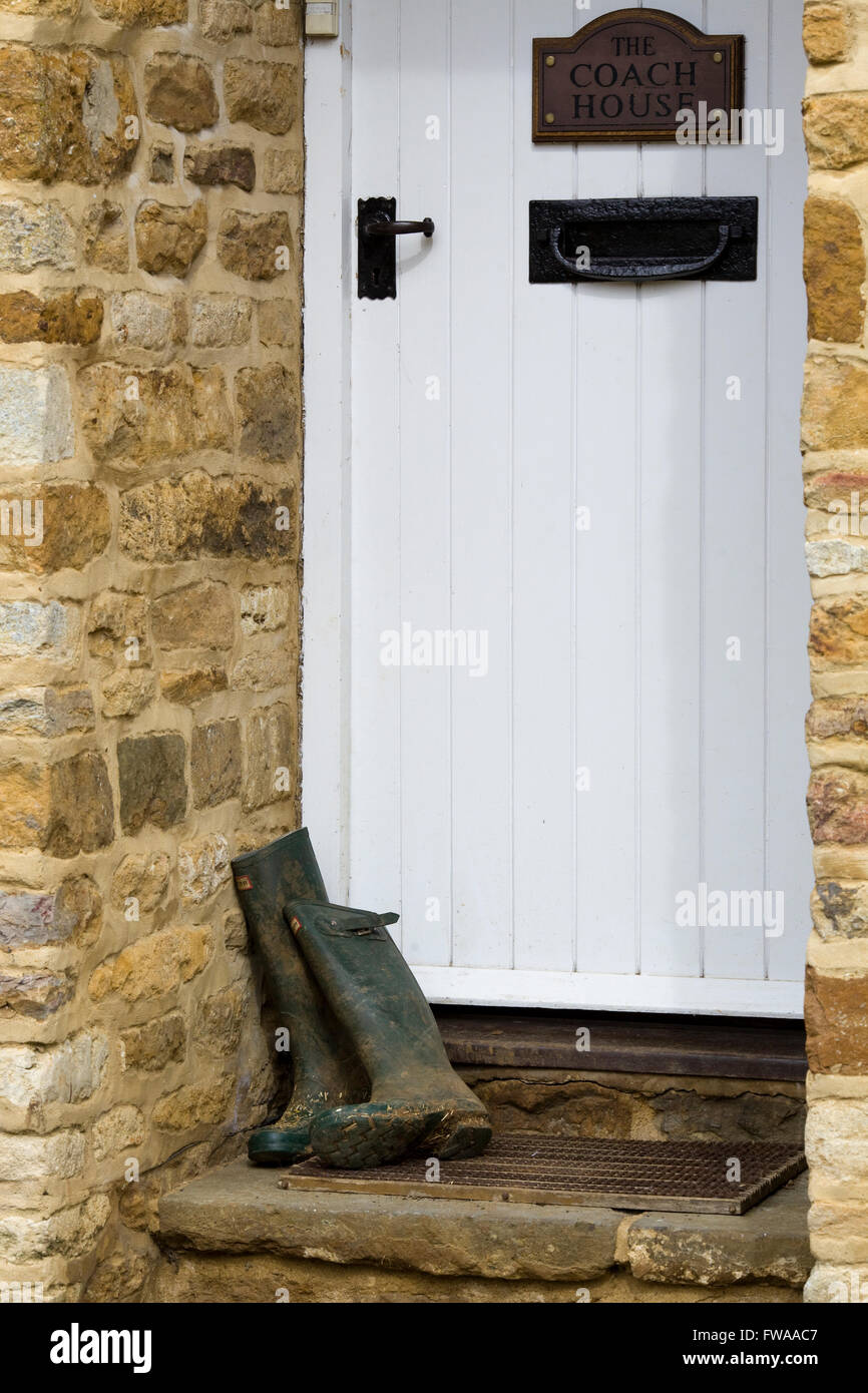 wooden front door with wellington boots in doorway at a countryside ...