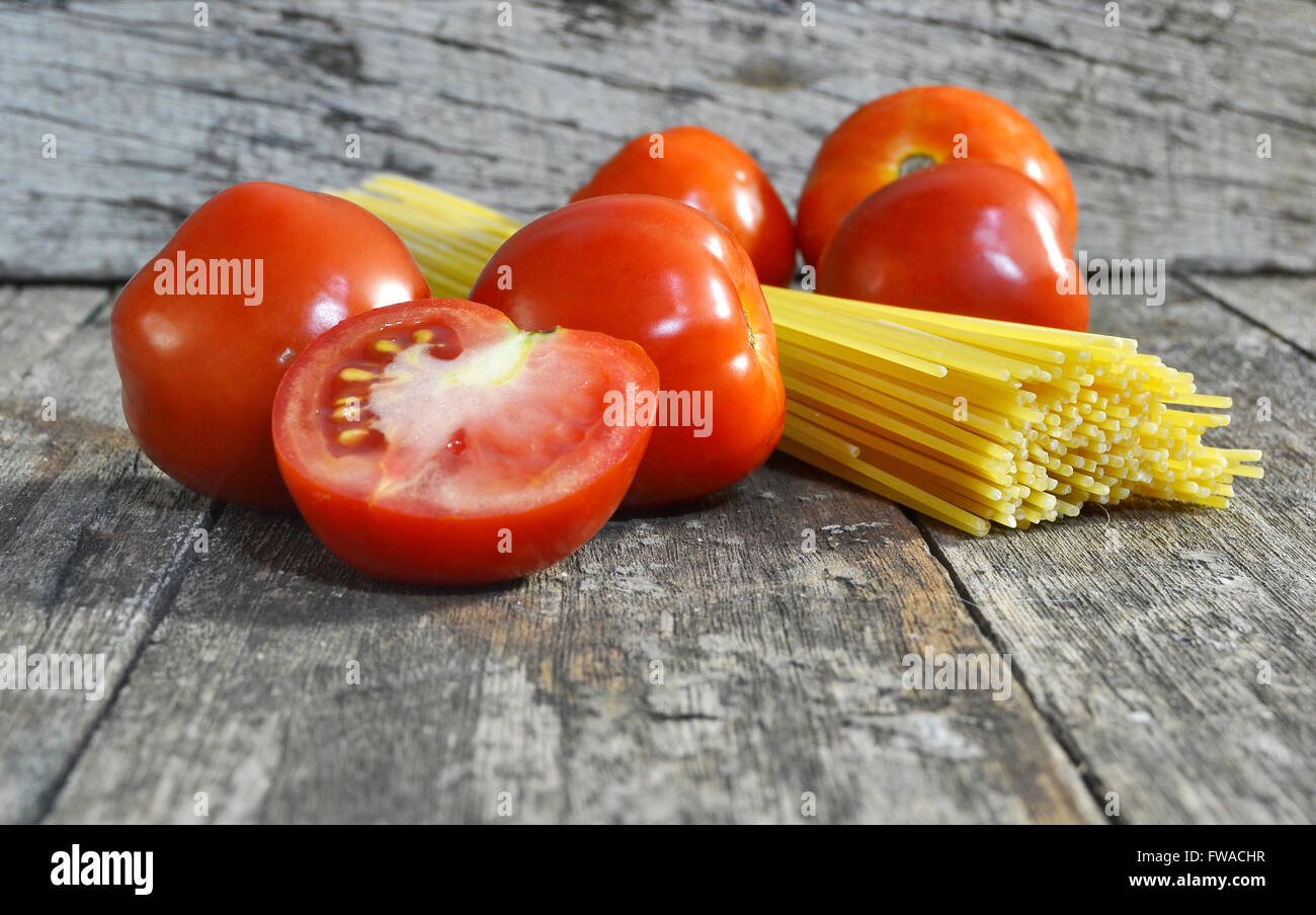 raw spaghetti stack with fresh tomatoes Stock Photo - Alamy