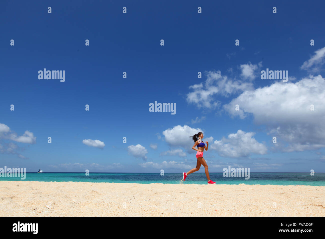 Running woman jogging on beach and sea on background Stock Photo - Alamy
