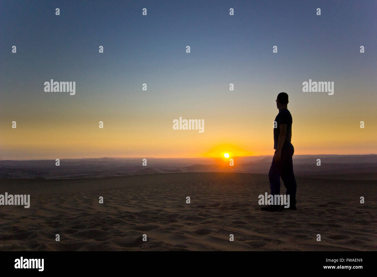 standing man at sunset in desert with shining sun Stock Photo - Alamy