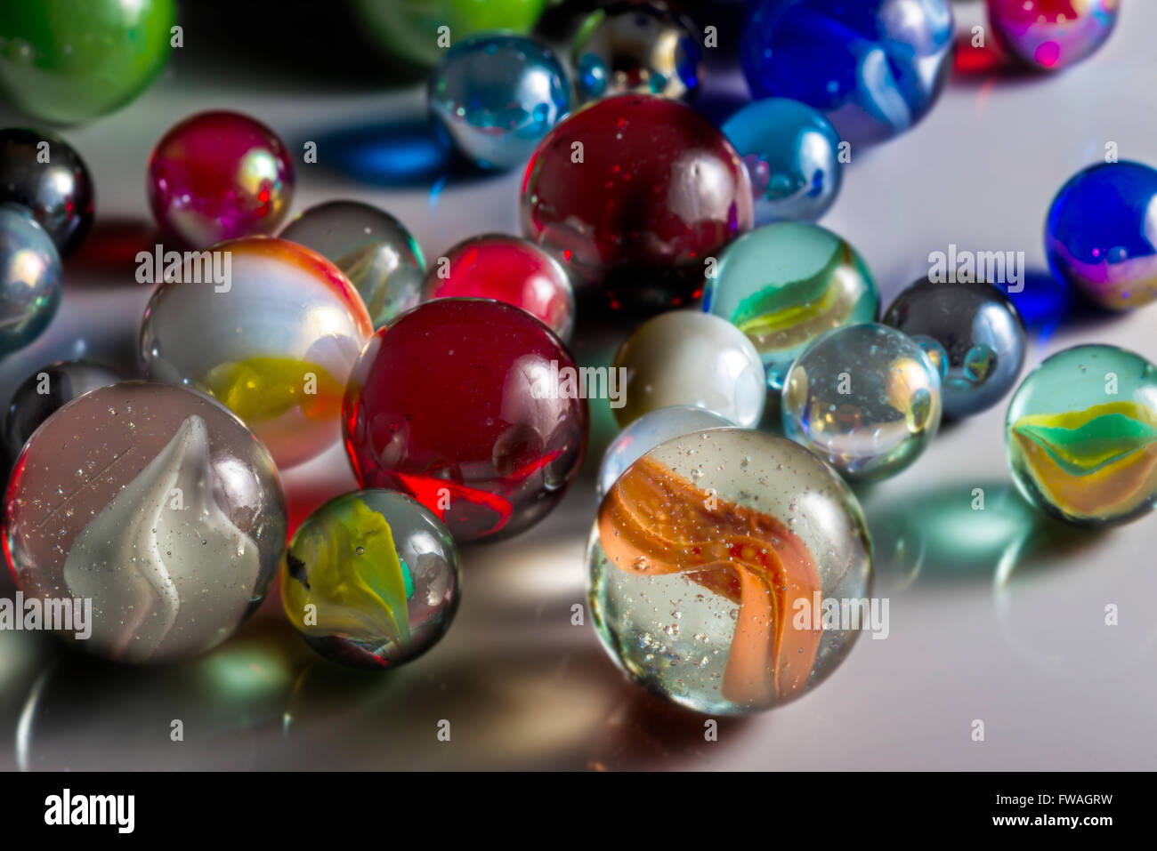 Closeup view of translucent marbles on a shiny surface Stock Photo - Alamy