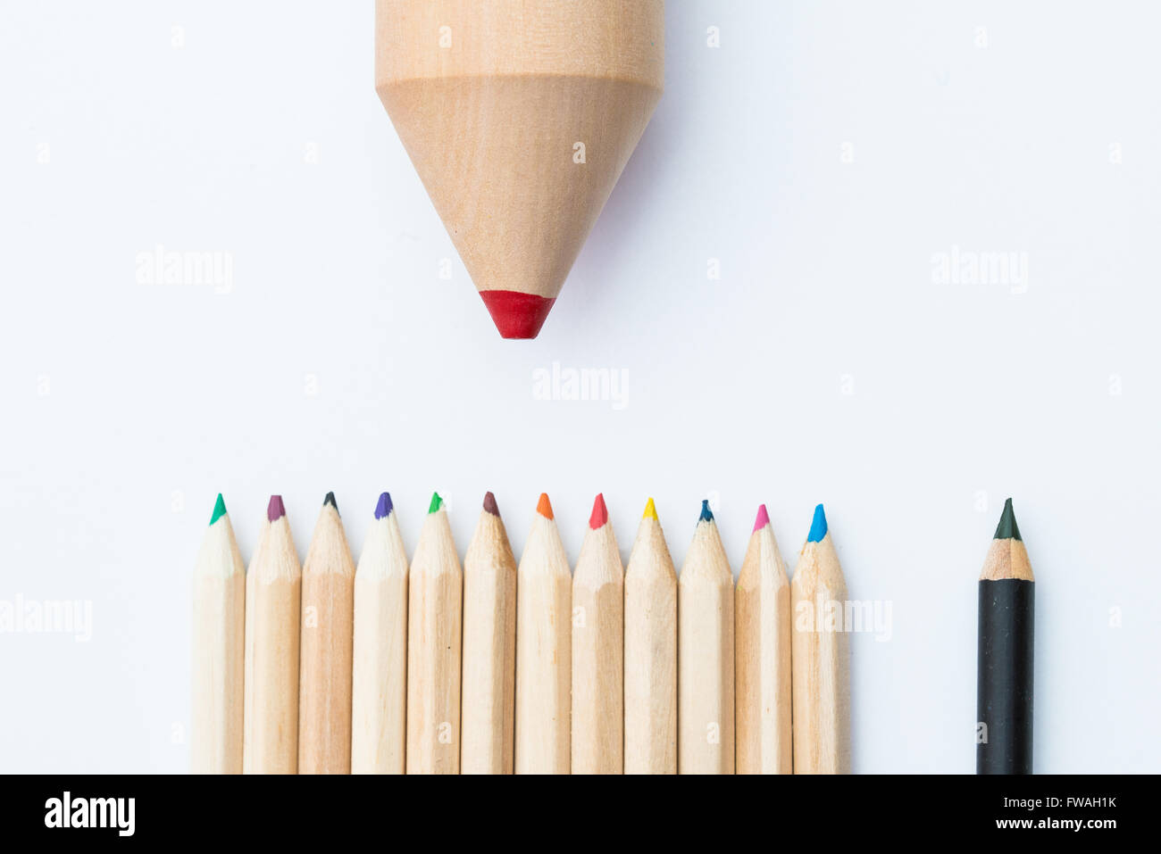 small pile of crayons and one huge crayon Stock Photo - Alamy