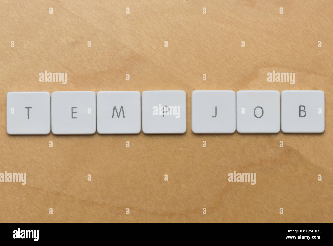 Keyboard Letters spell temp job on desktop background Stock Photo - Alamy