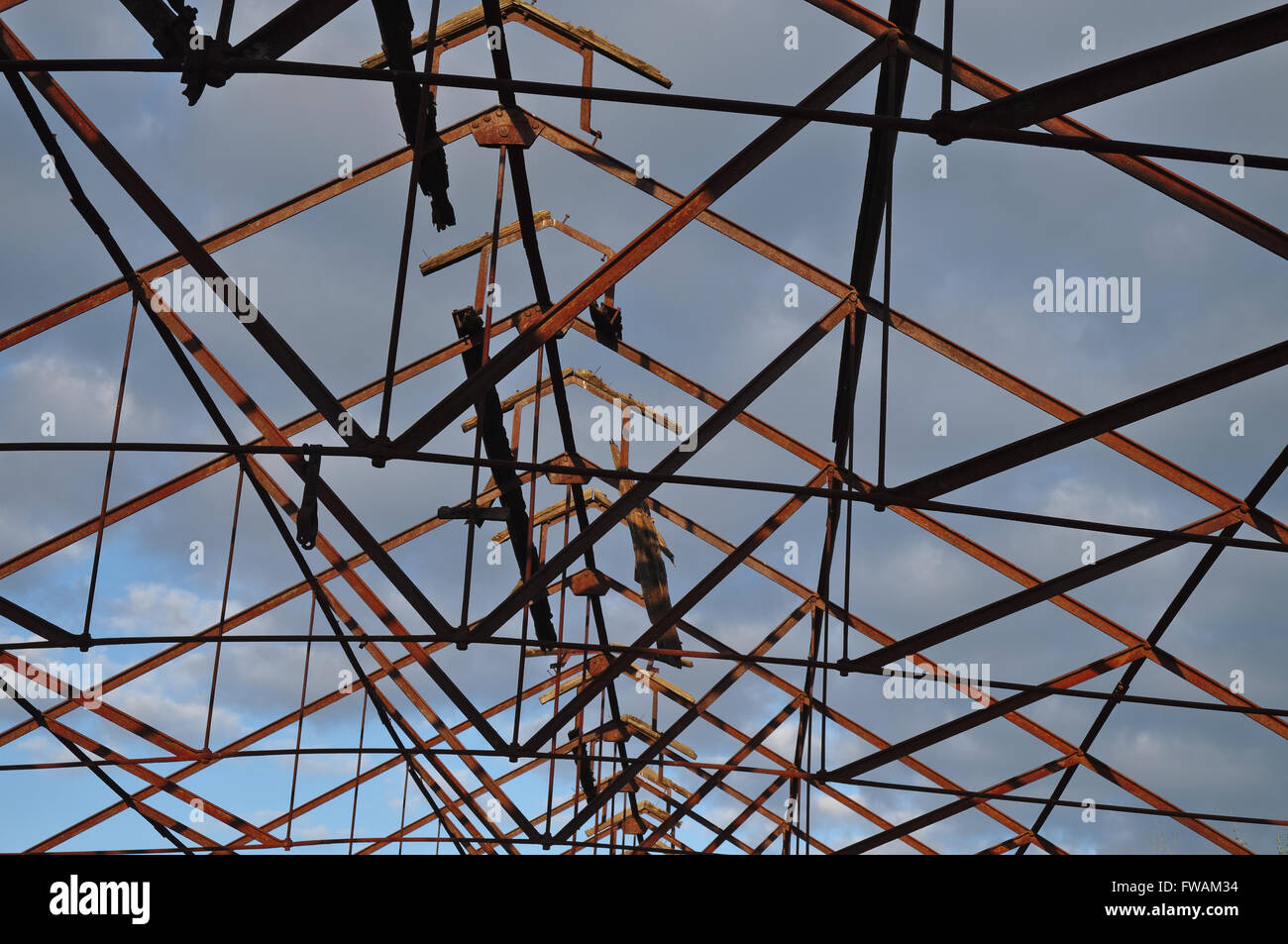 Collapsed roof and rusty iron structure. Ruins and decay Stock Photo ...