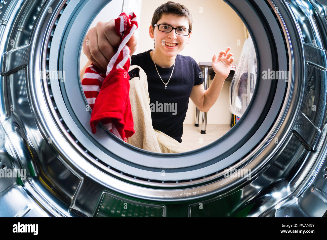 Funny men loading clothes to washing machine Stock Photo - Alamy