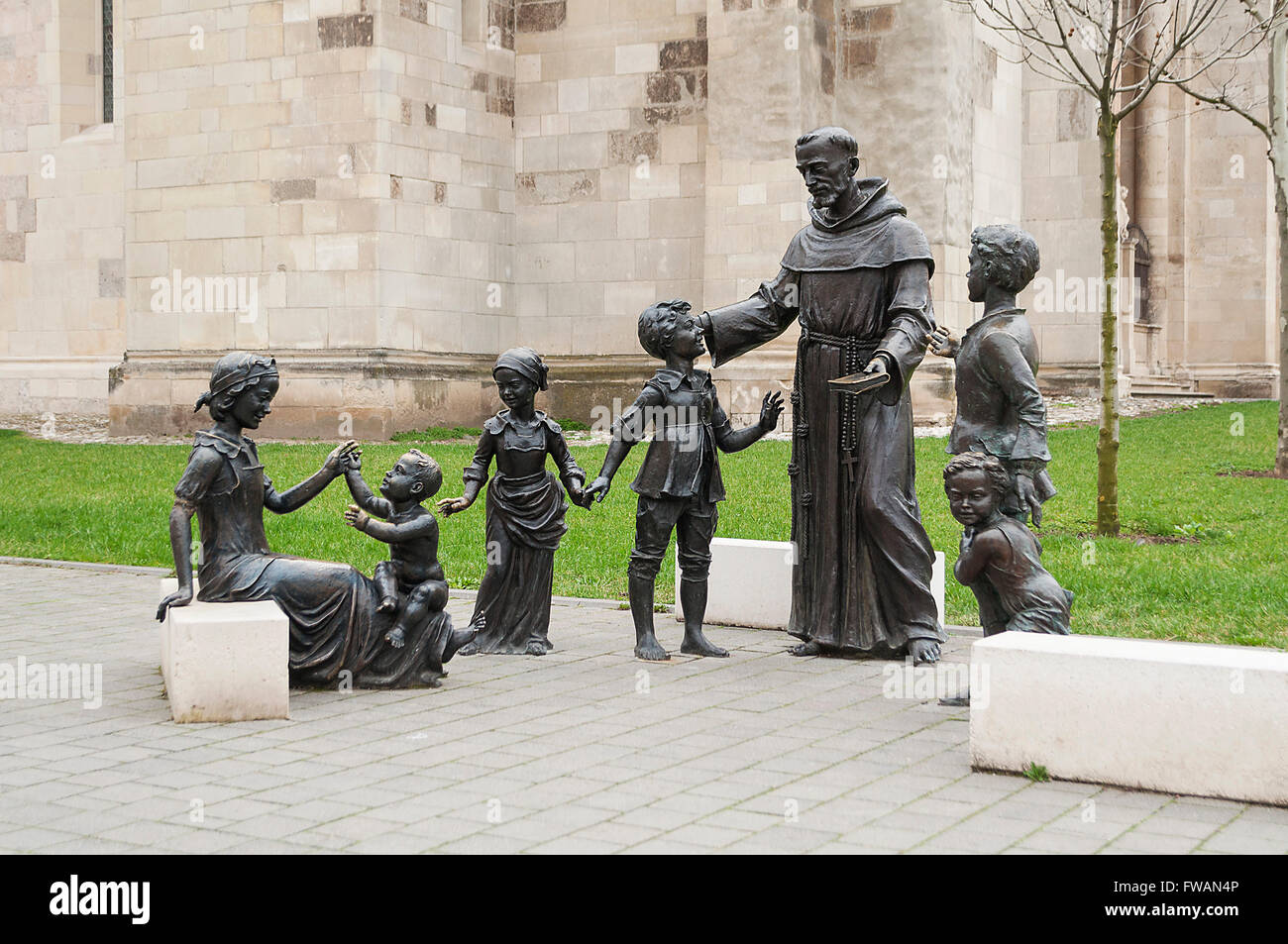 Sculpture of a priest teaching kids religion. Bronze statues Stock ...