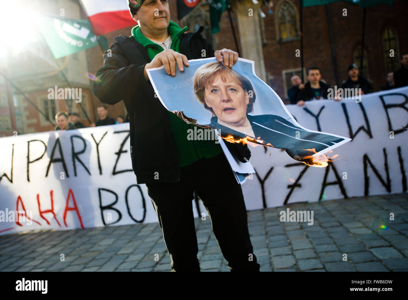 Protester burns picture of Angela Merkel during anti immigrant and anti ...