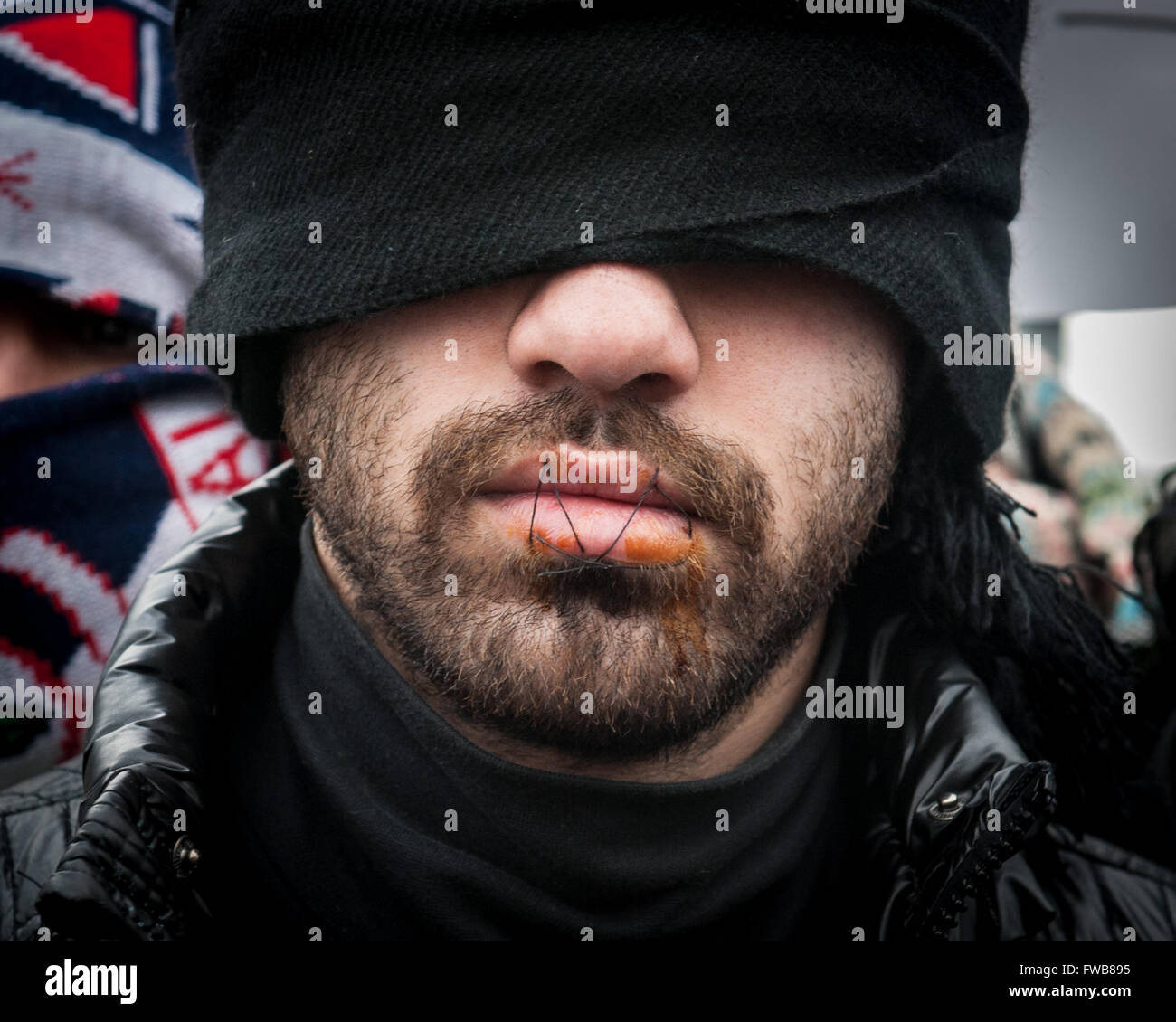 A group of Iranian asylum seekers stitch up their mouths to signify ...